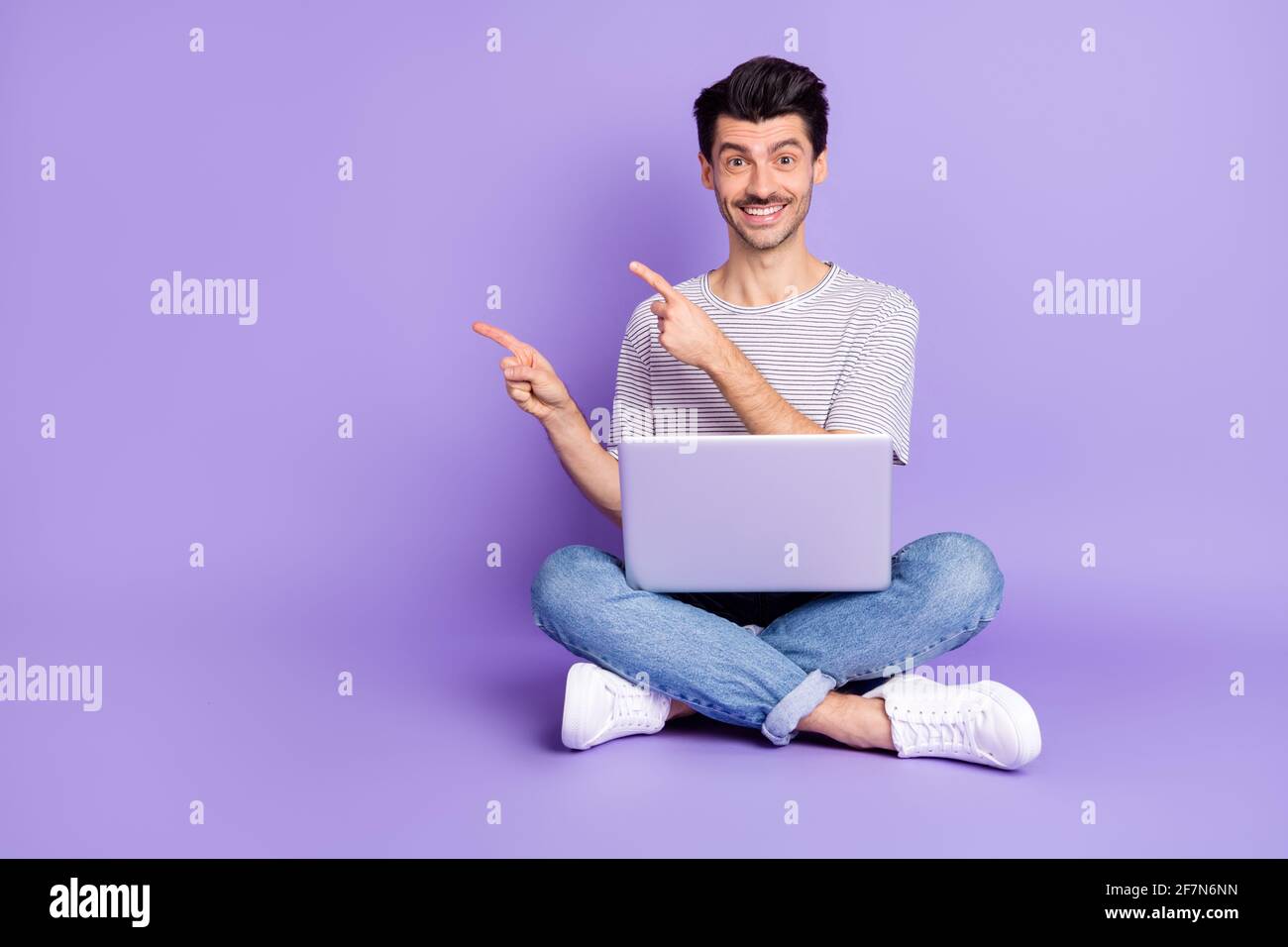 Photo of guy sit floor hold netbook direct fingers empty space wear ...