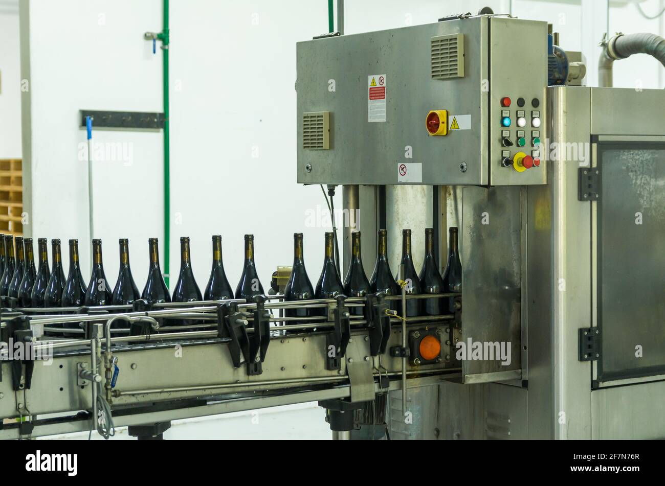 Wine production machine, filling the bottles. Industrial production ...