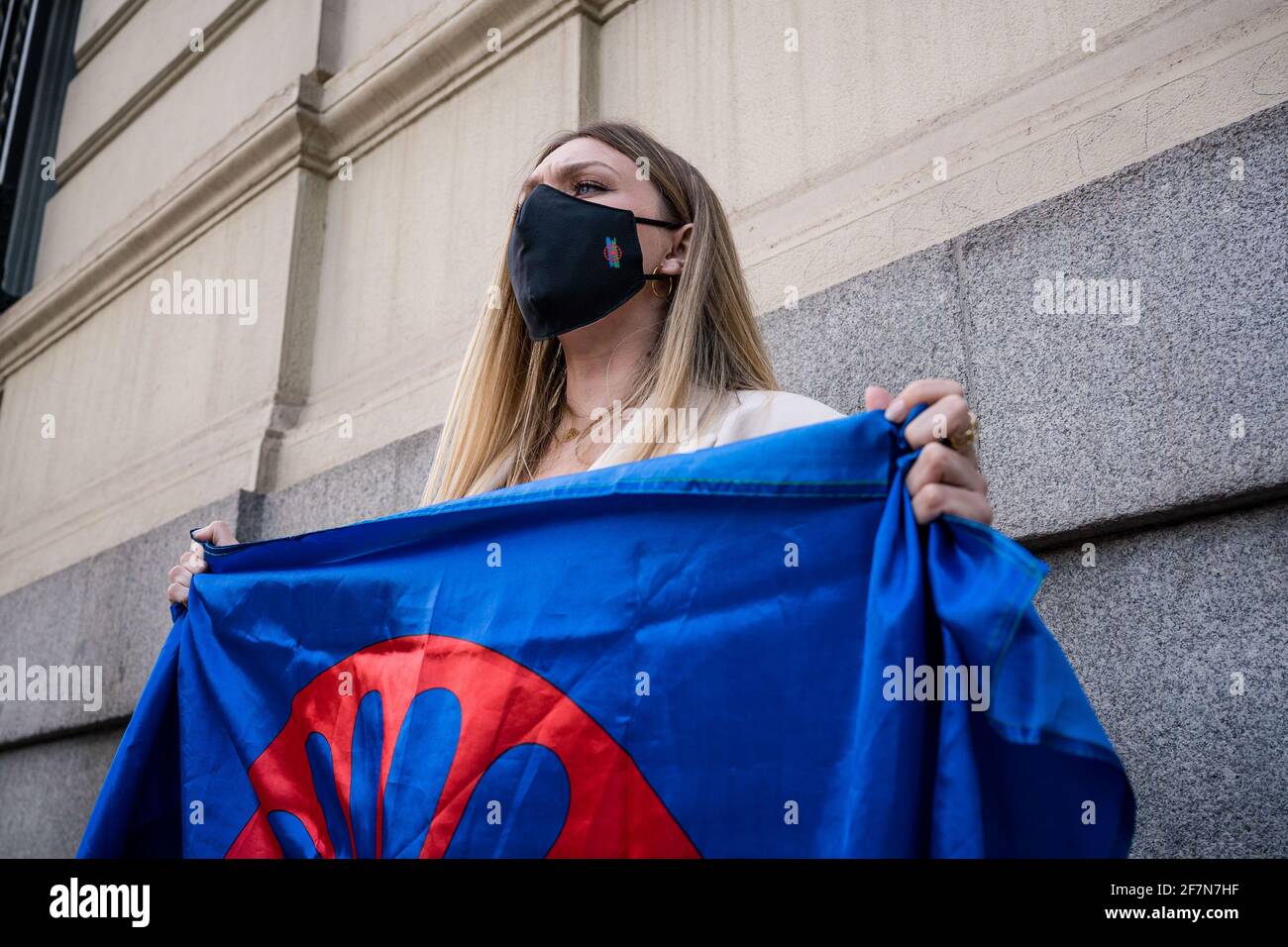 A woman holds a gypsy flag during the demonstration. As part of the ...