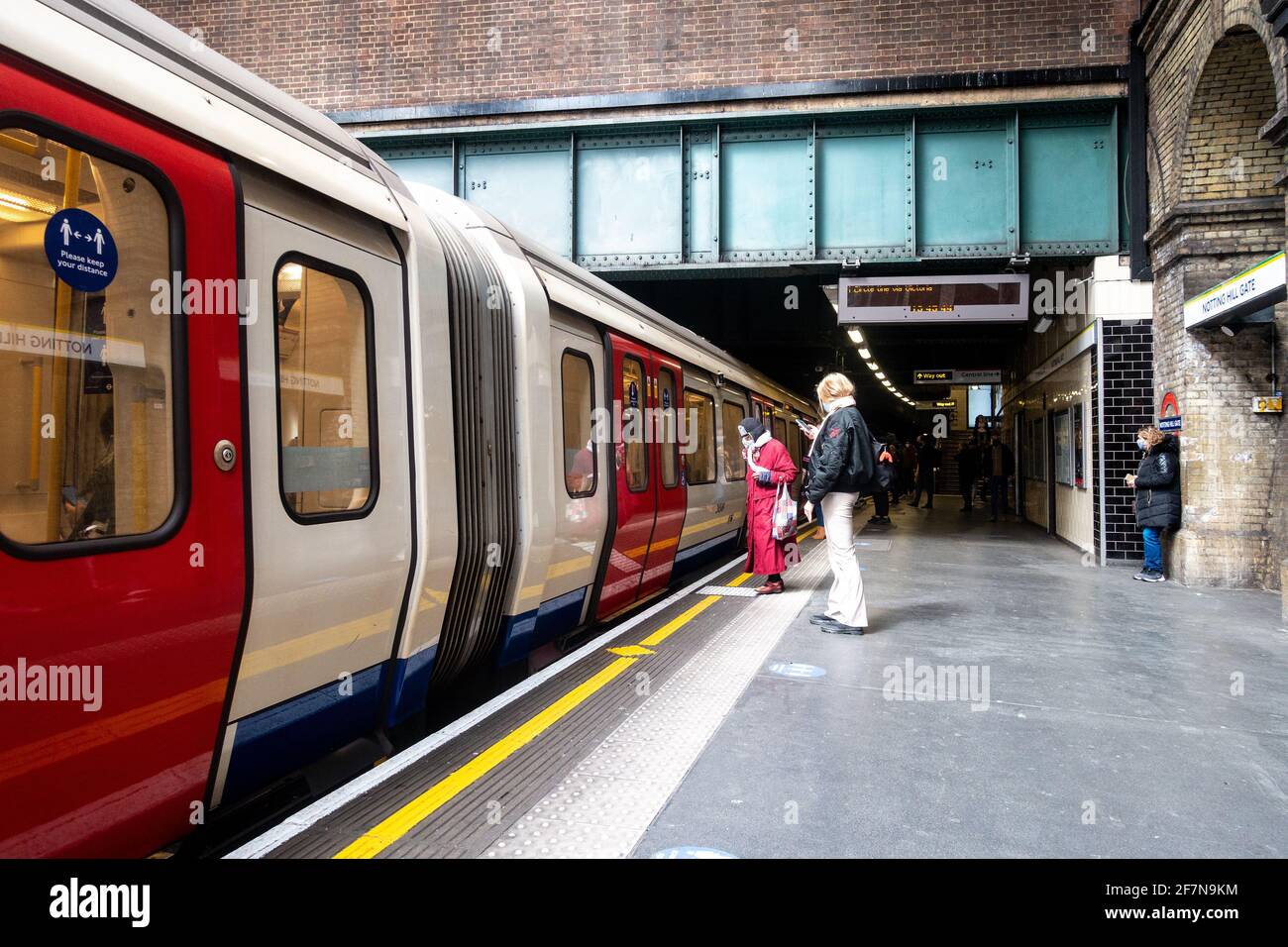 Passengers wait for the doors to open on a train which has just arrived ...