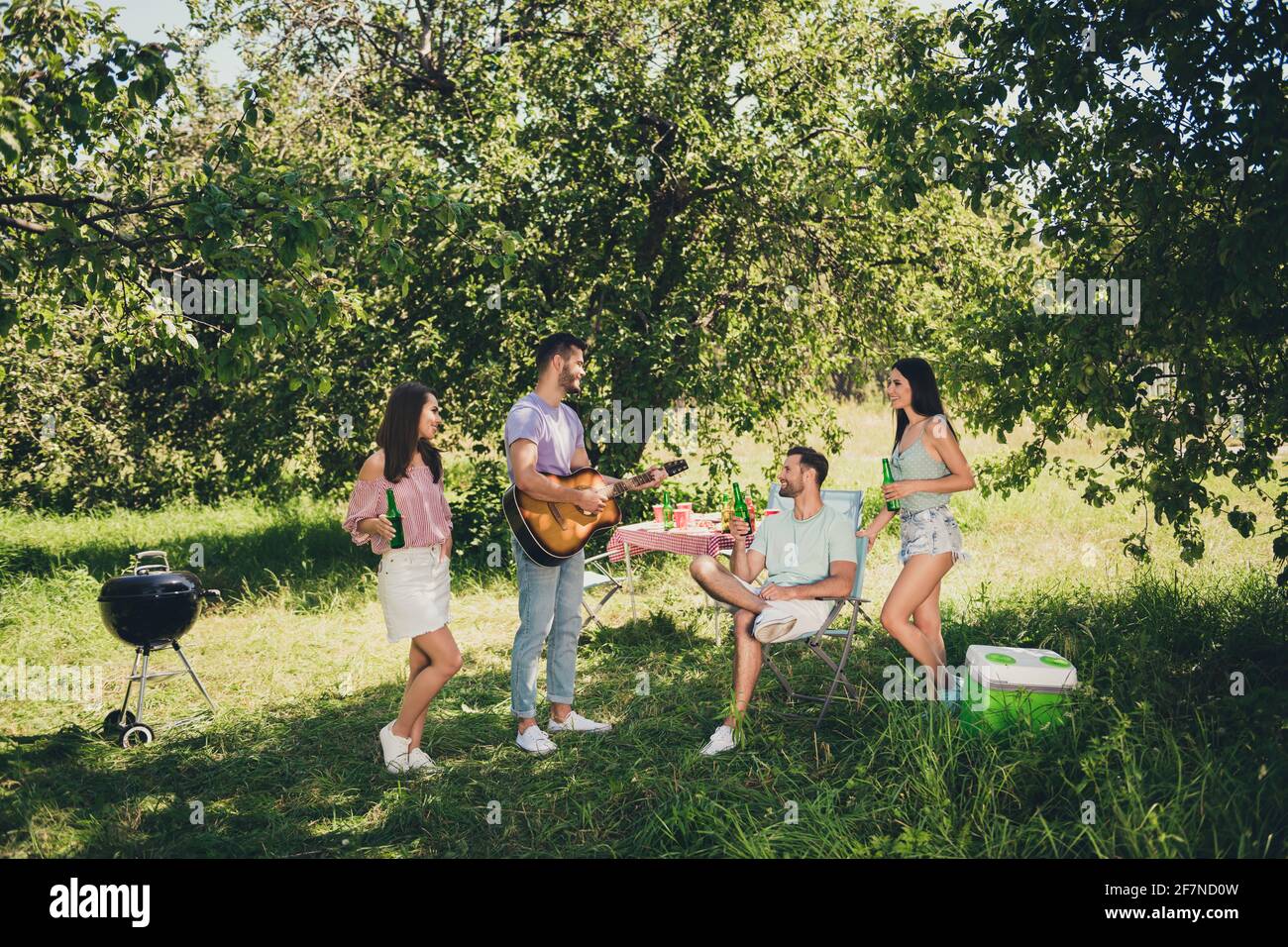 Full length photo of four happy friends weekend party hold beer bottle ...
