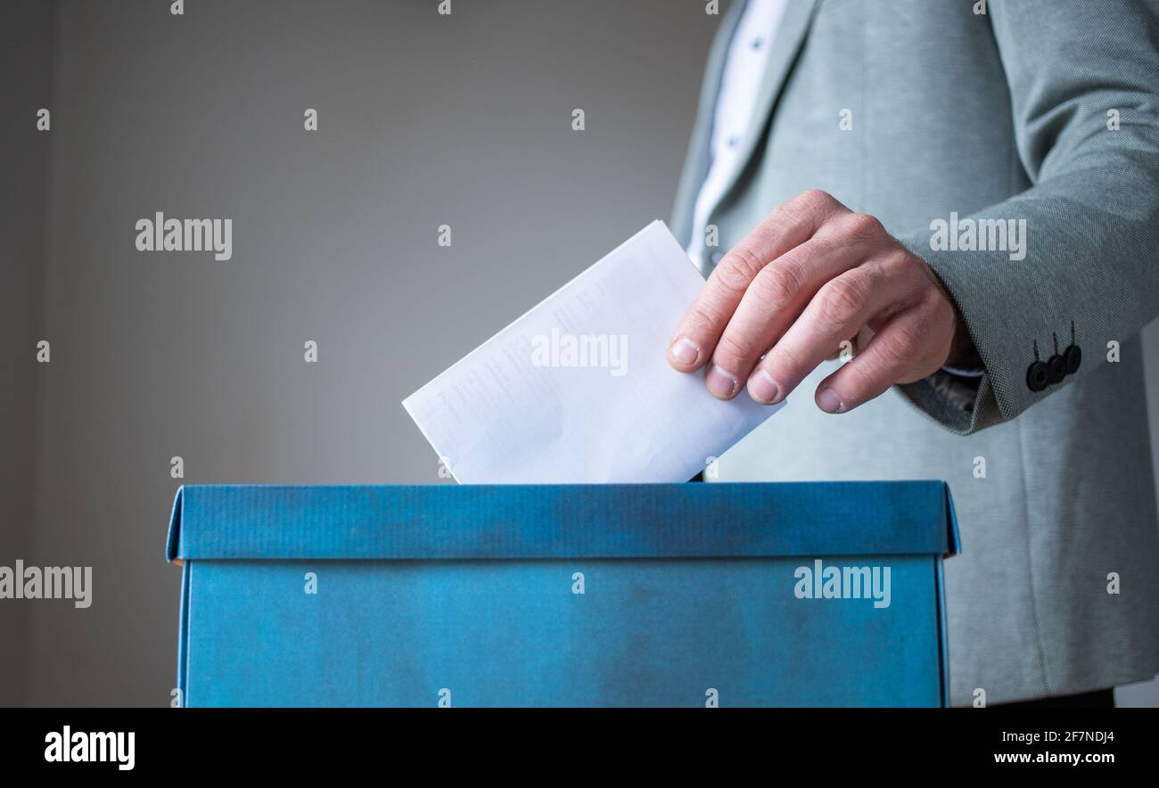 Hand putting voting bulletin hi-res stock photography and images - Alamy