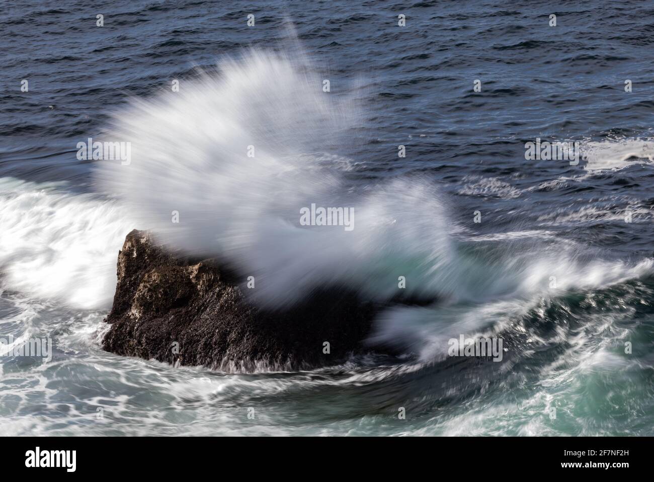 Wave Breaking onto ocean rocks Stock Photo - Alamy