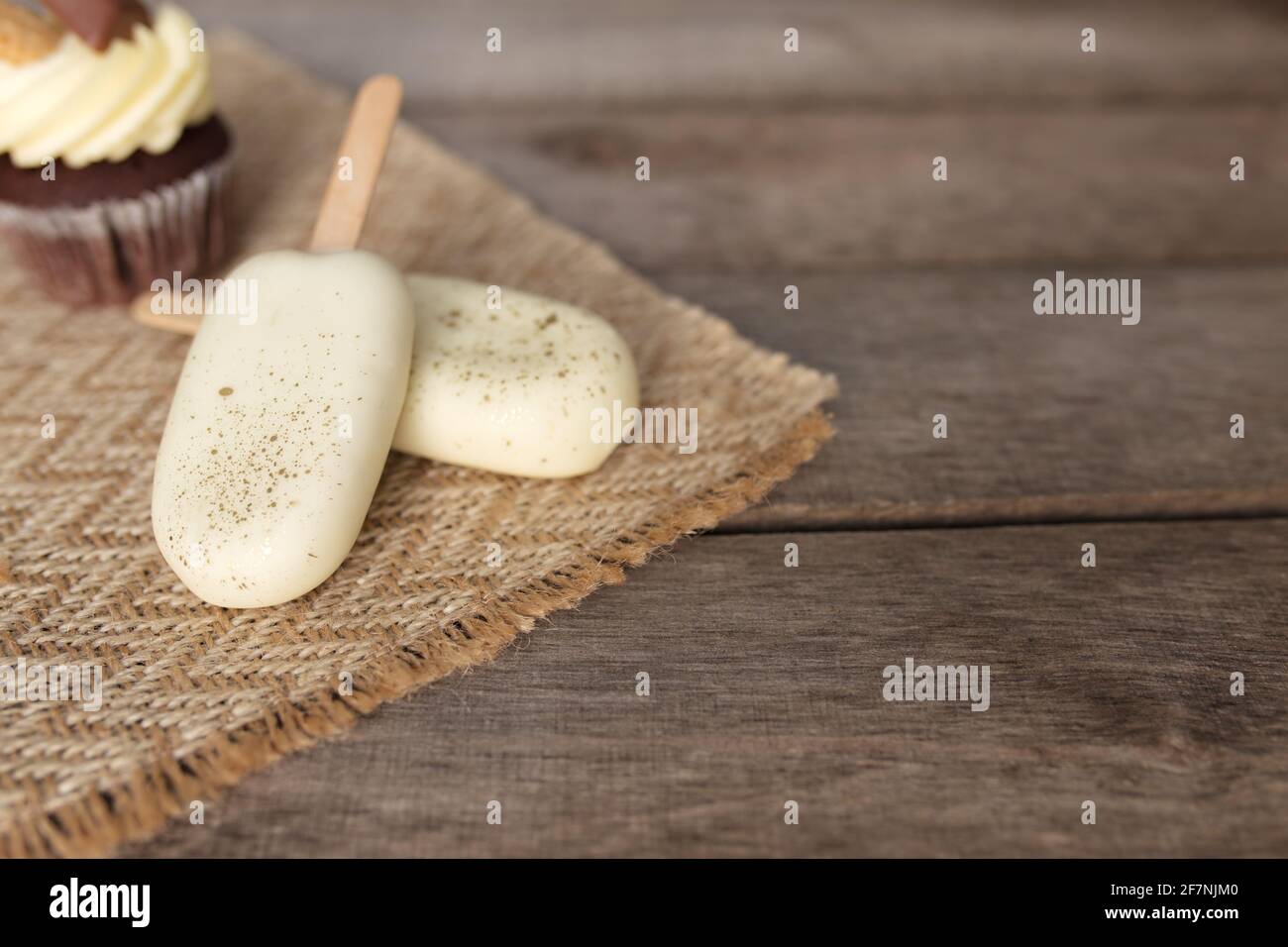 White cookie ice creams on a stick and tasty muffins and cupcakes on a ...