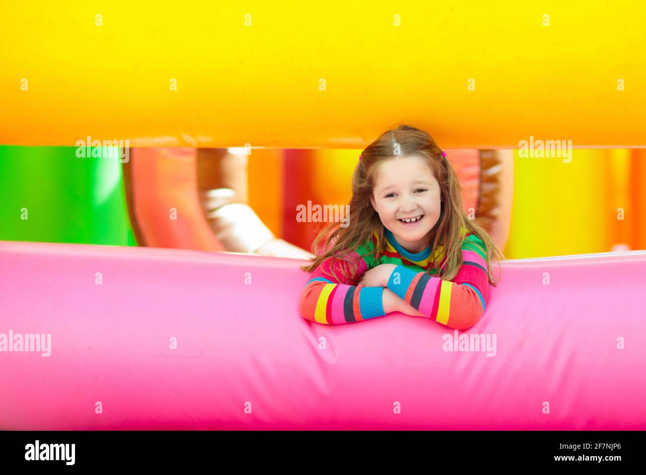 Child jumping on colorful playground trampoline. Kids jump in ...