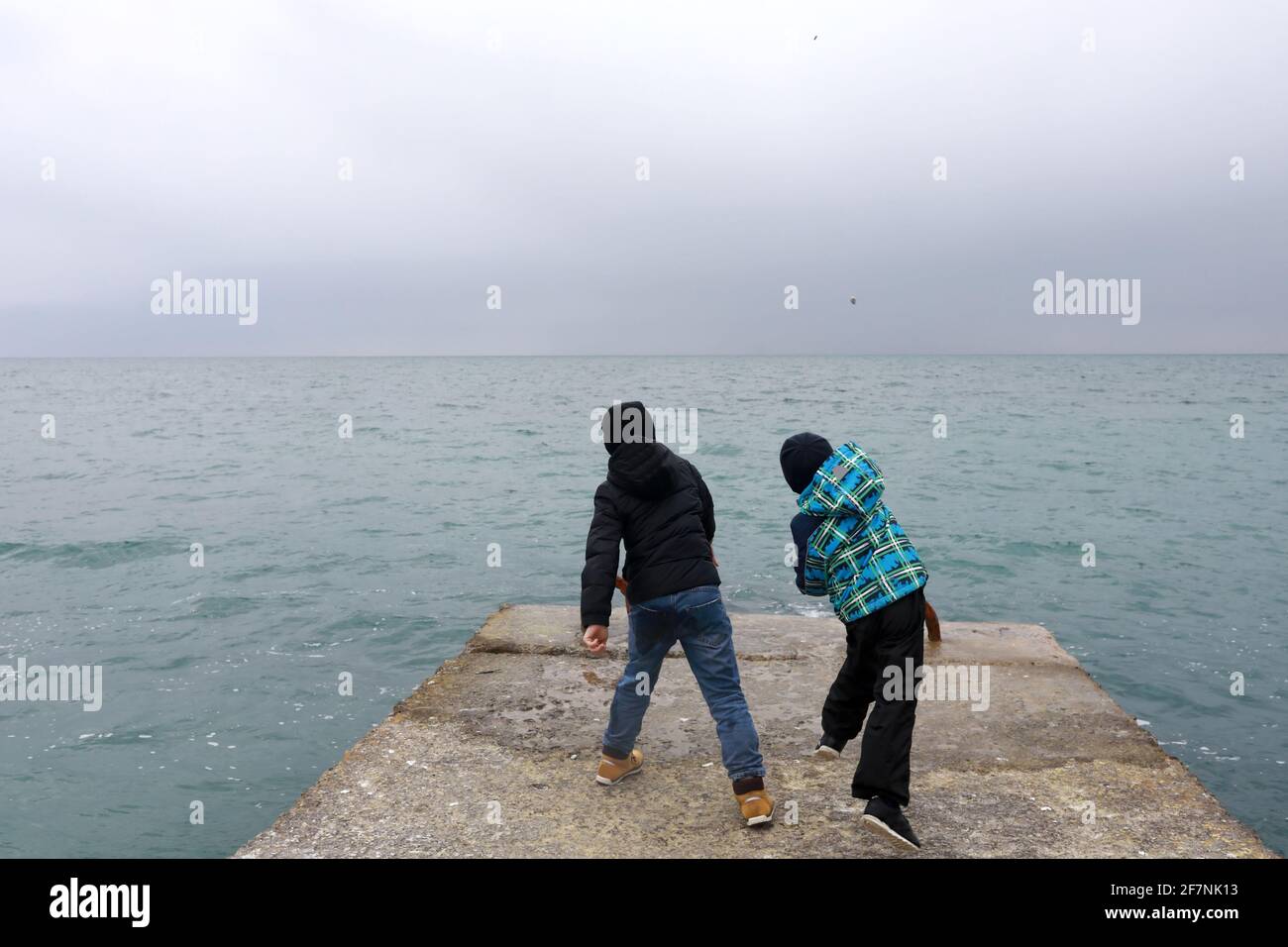 Child throwing stone sea hi-res stock photography and images - Alamy