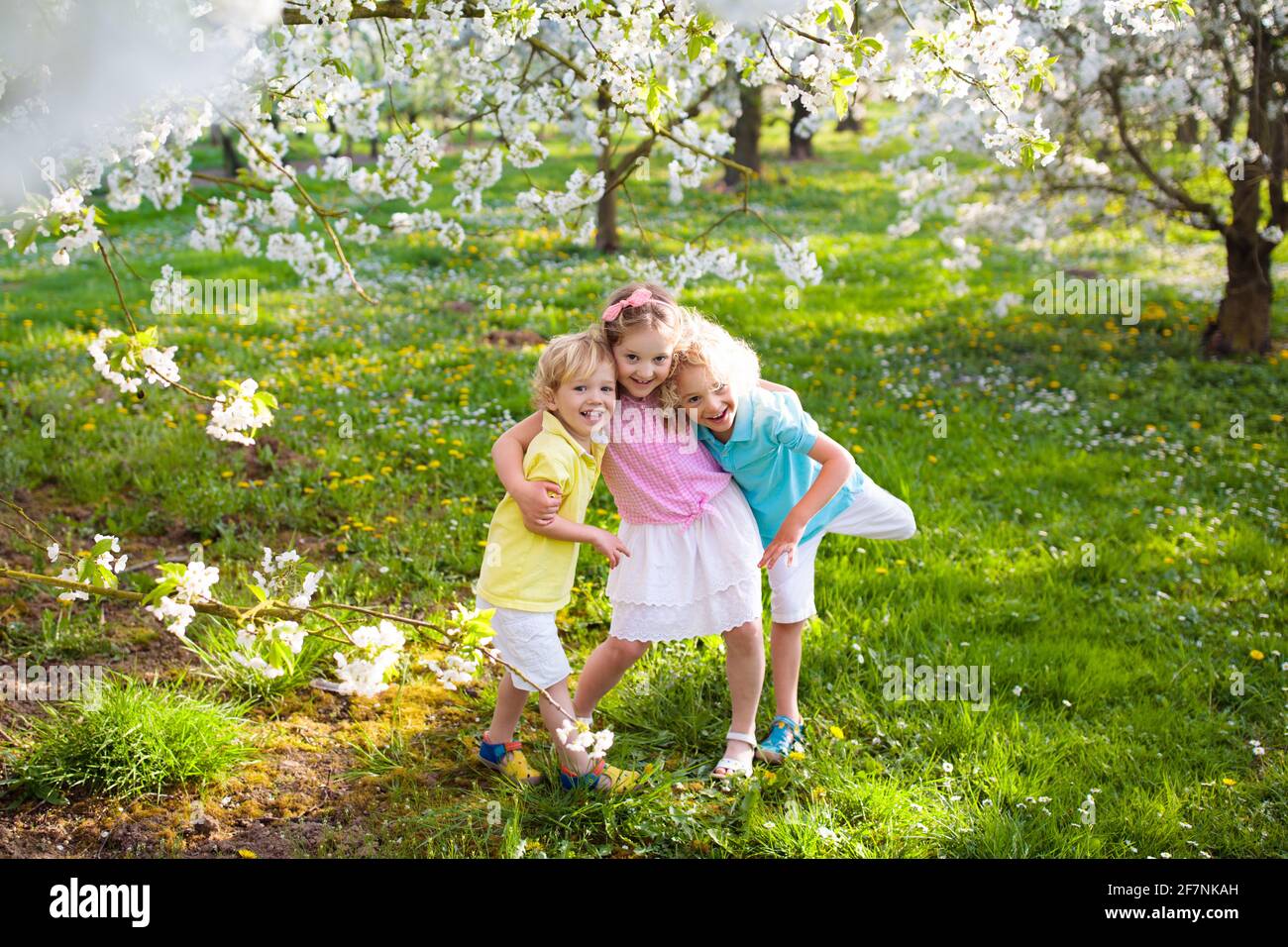 Kids playing in spring park. Children running in sunny garden with ...