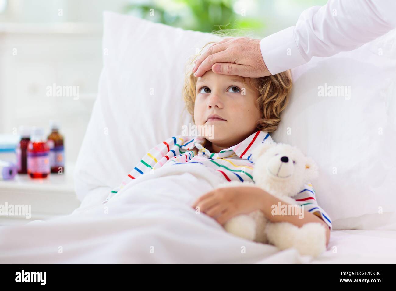 Sick little boy with medicine. Mother checking fever of ill child in ...