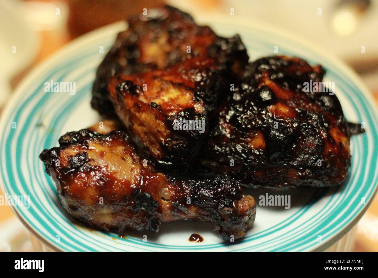 A blue and white striped plate of barbecue chicken pieces Stock Photo ...