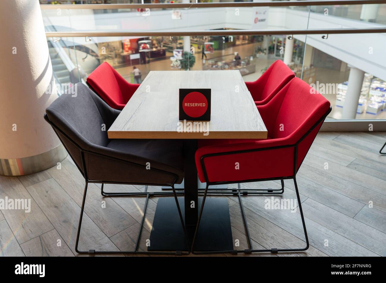 A table and soft chairs for visitors to the food court of a modern ...