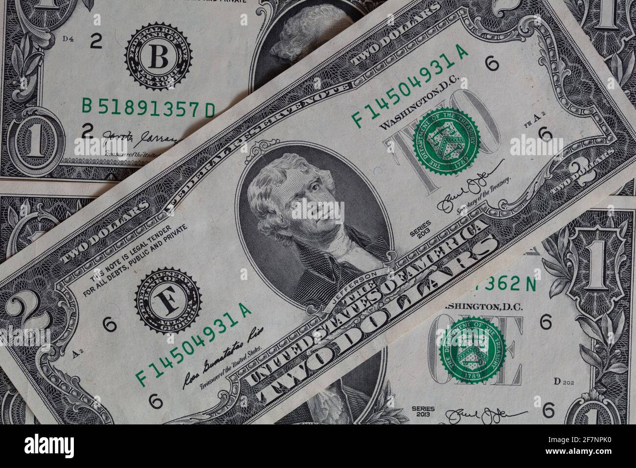 2 US dollar banknote on 1 dollar banknotes background Stock Photo - Alamy