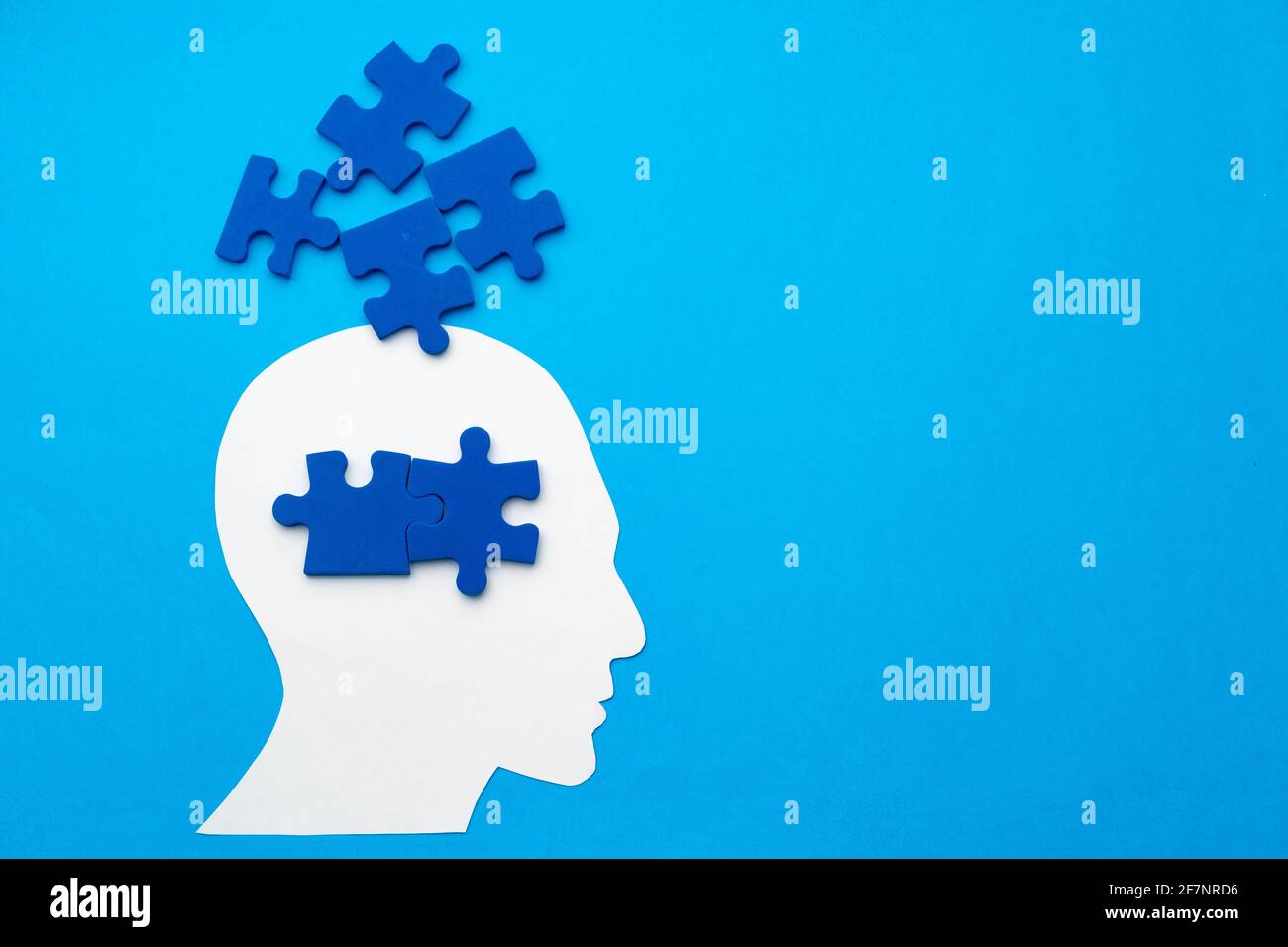 Papercut head with jigsaw puzzle pieces on blue background Stock Photo ...