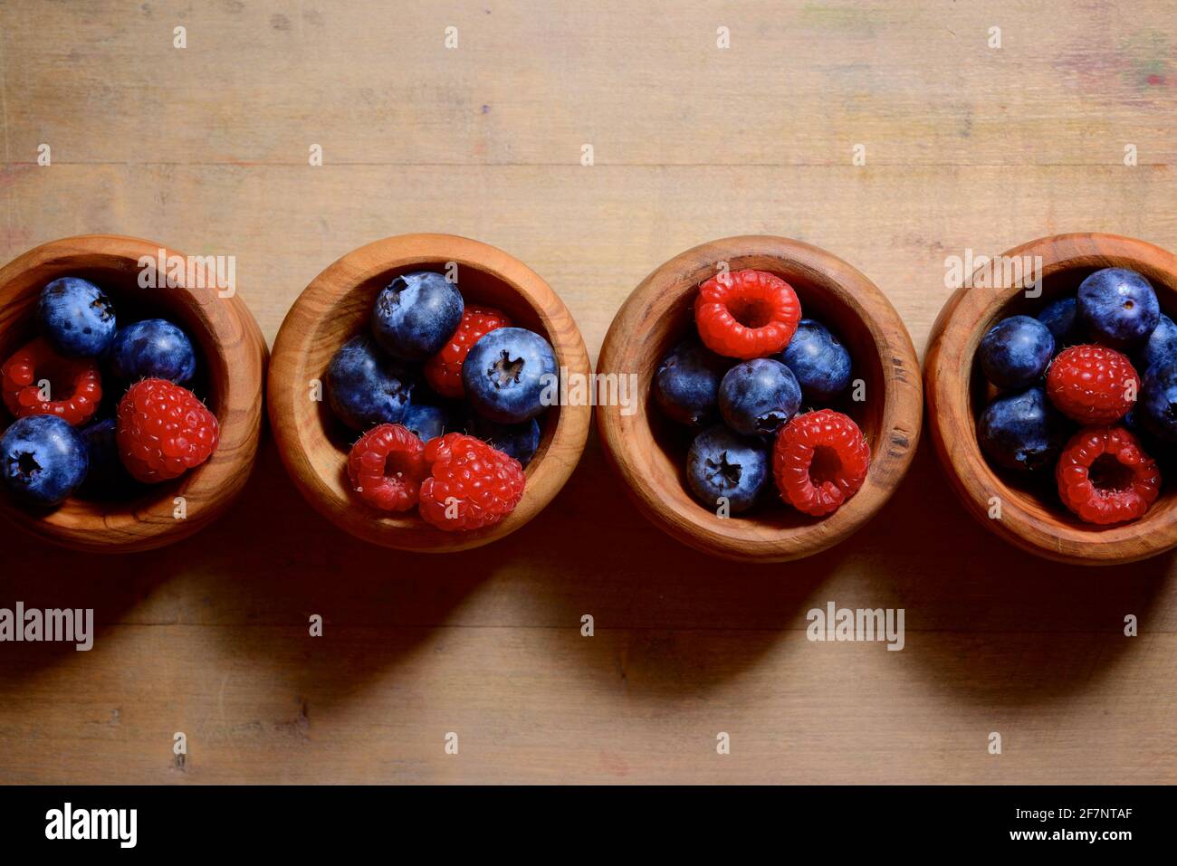 Raspberries and blueberries in wooden bowls Stock Photo - Alamy