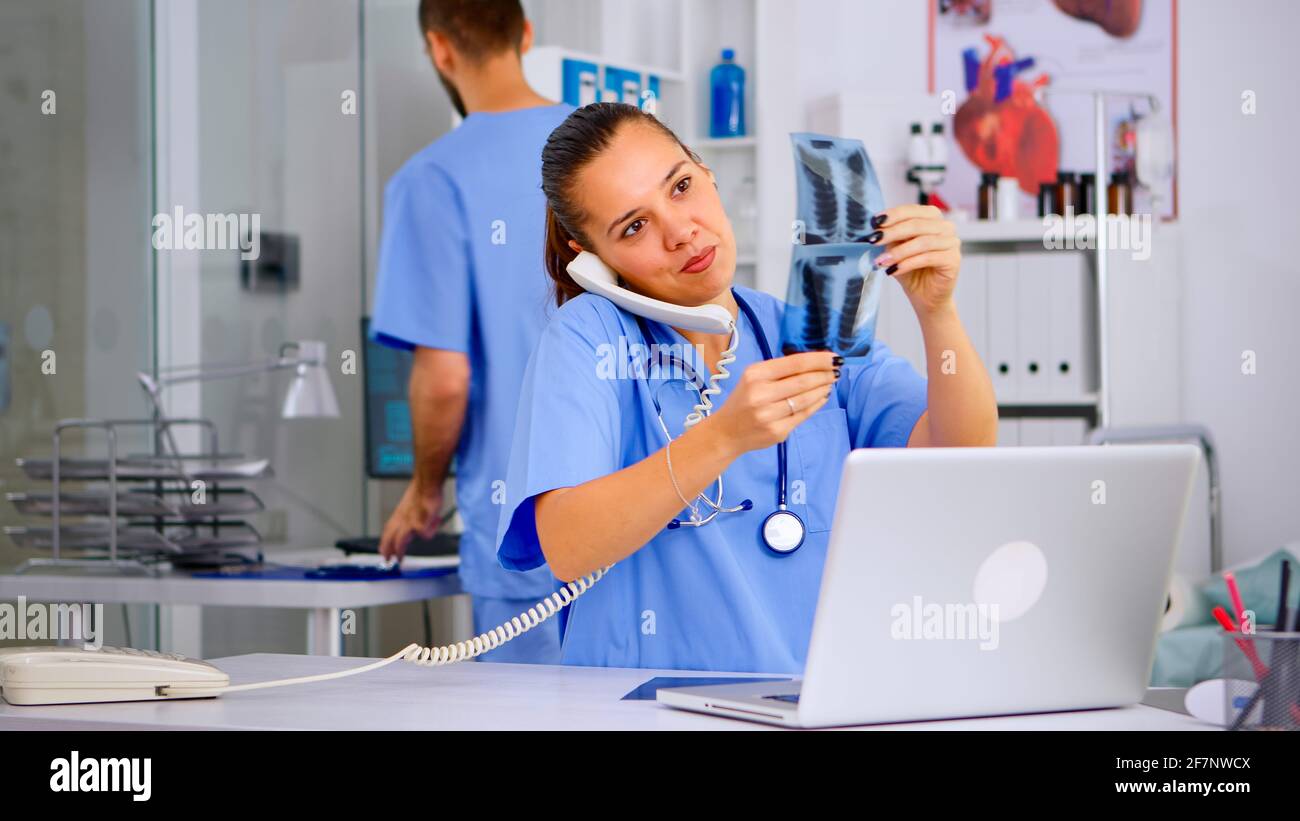 Physician nurse answering patient call by phone, looking at his ...