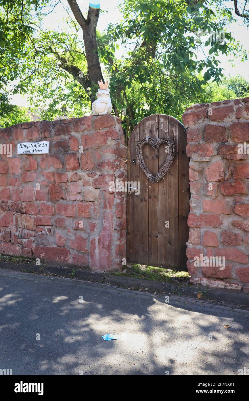 Gate in a brick fence along the street in a small German village on a ...