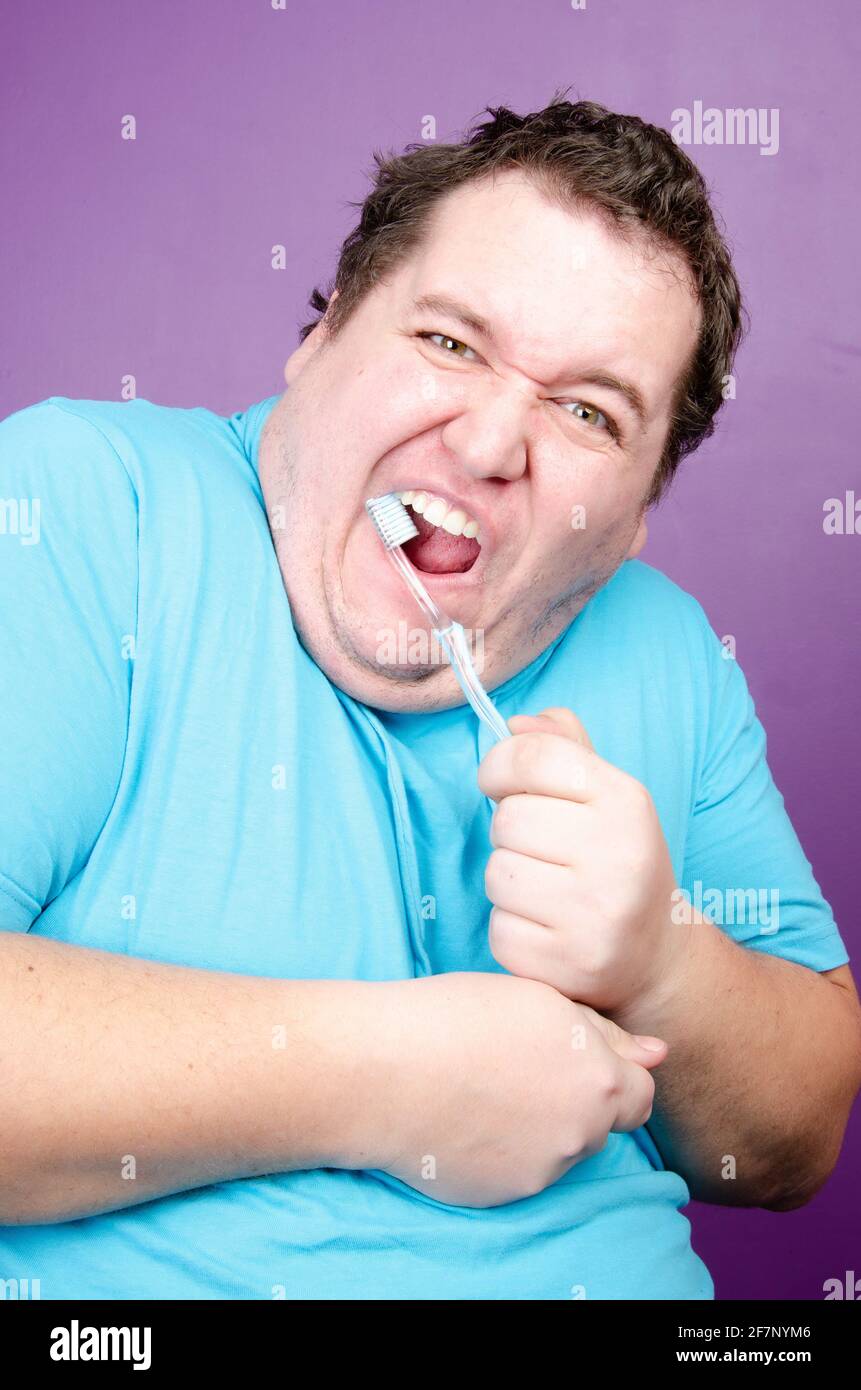Hygiene in the shower. Funny fat guy is brushing his teeth Stock Photo ...