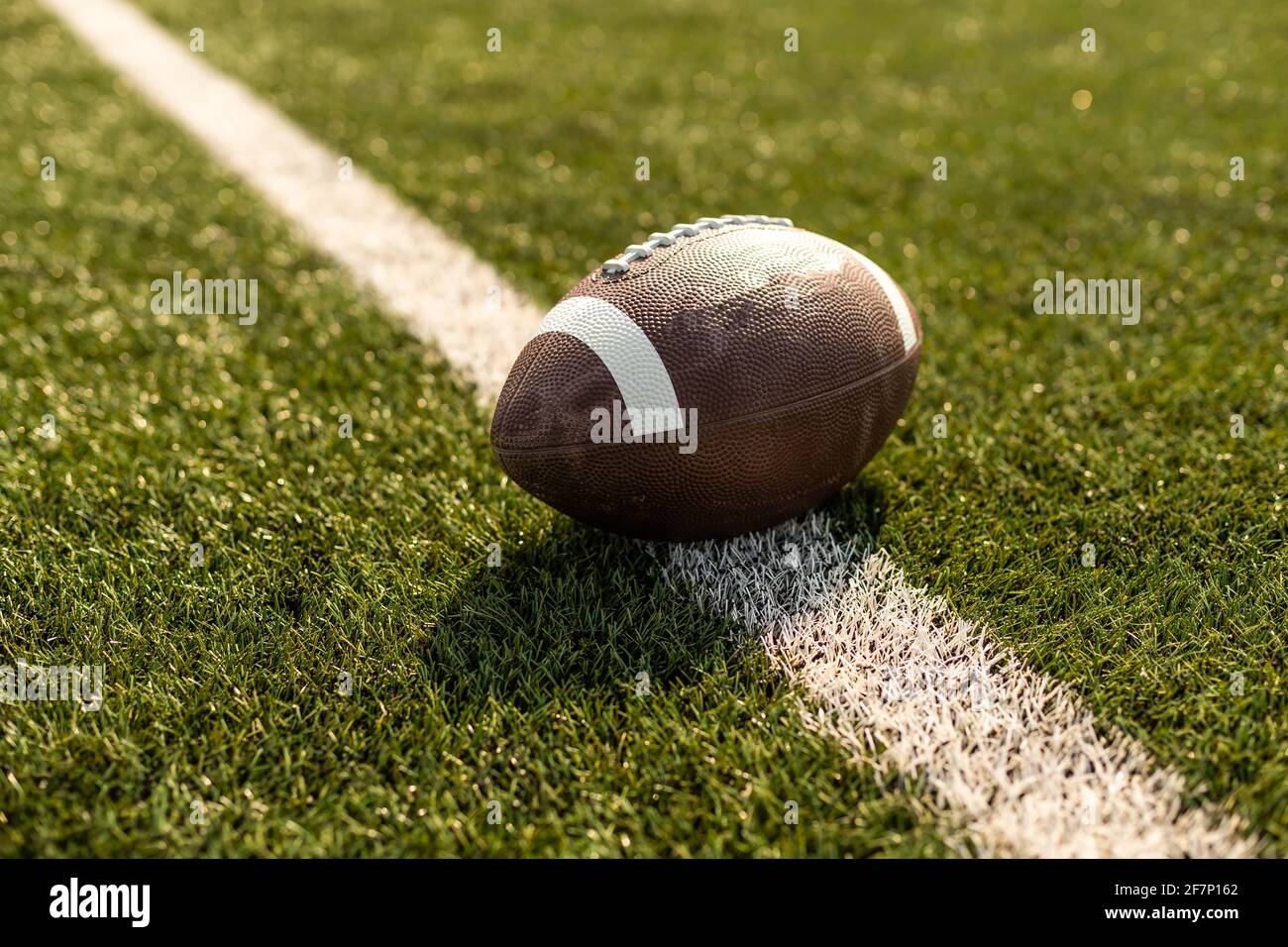 American rugby ball on the grass in the stadium Stock Photo - Alamy