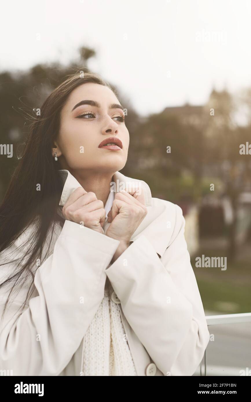 Outdoor portrait of a young beautiful fashionable lady wearing stylish ...