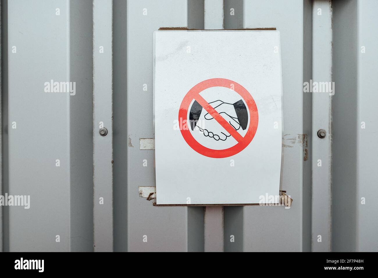 the handshake ban sign. a warning sign hangs on the wall. you can not ...