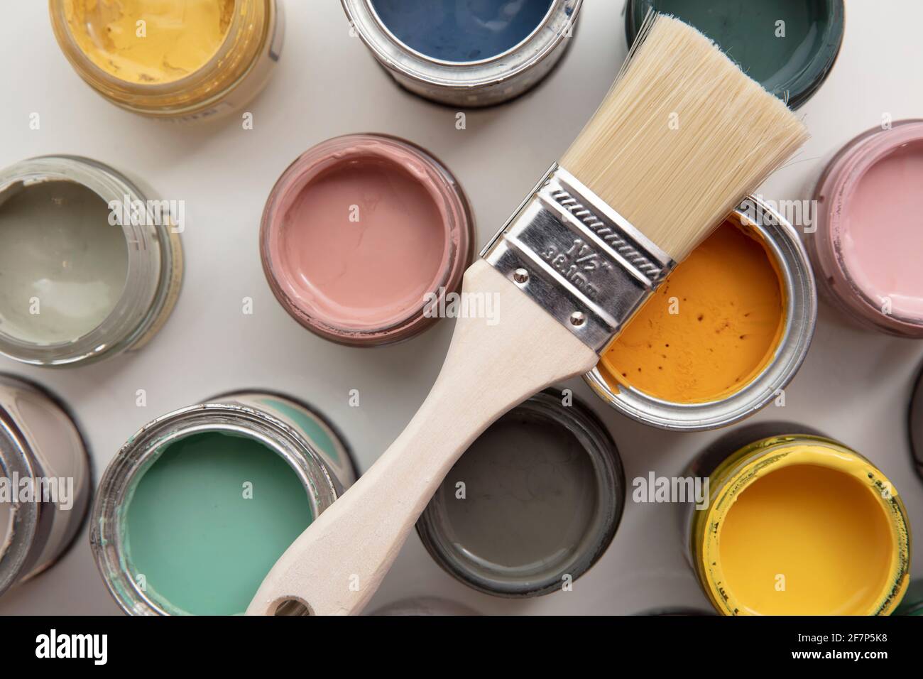 Overhead view of a DIY paint brush with colorful sample paint pots ...