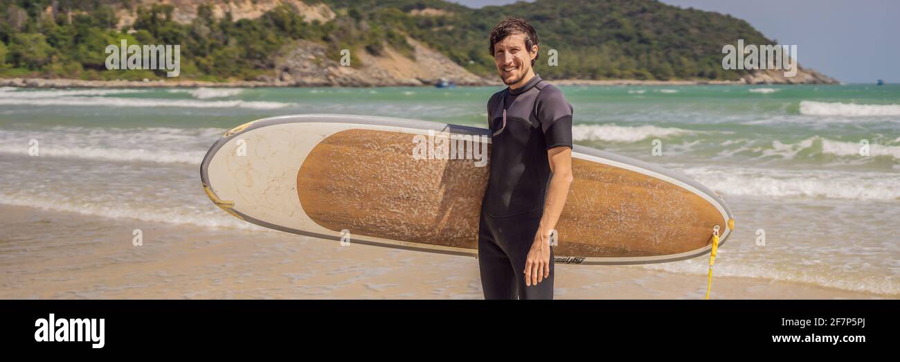 BANNER, LONG FORMAT Young surfer standing agains the ocean looking the ...