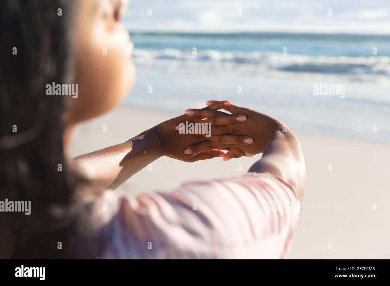 Mixed race woman on beach holiday stretching hands Stock Photo - Alamy
