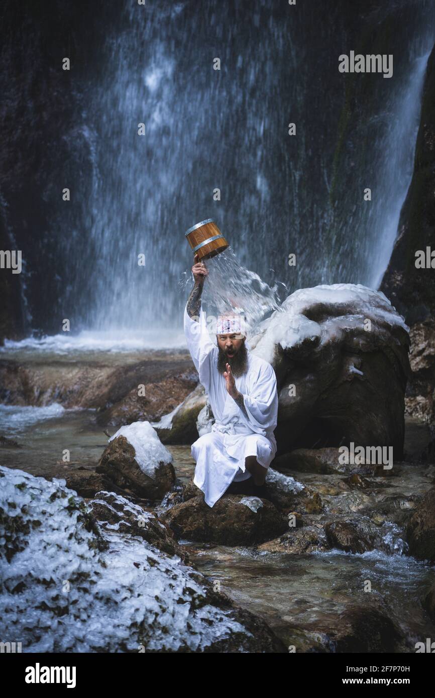 Man in traditional Japanese shugendo outfit doing waterfall meditation ...