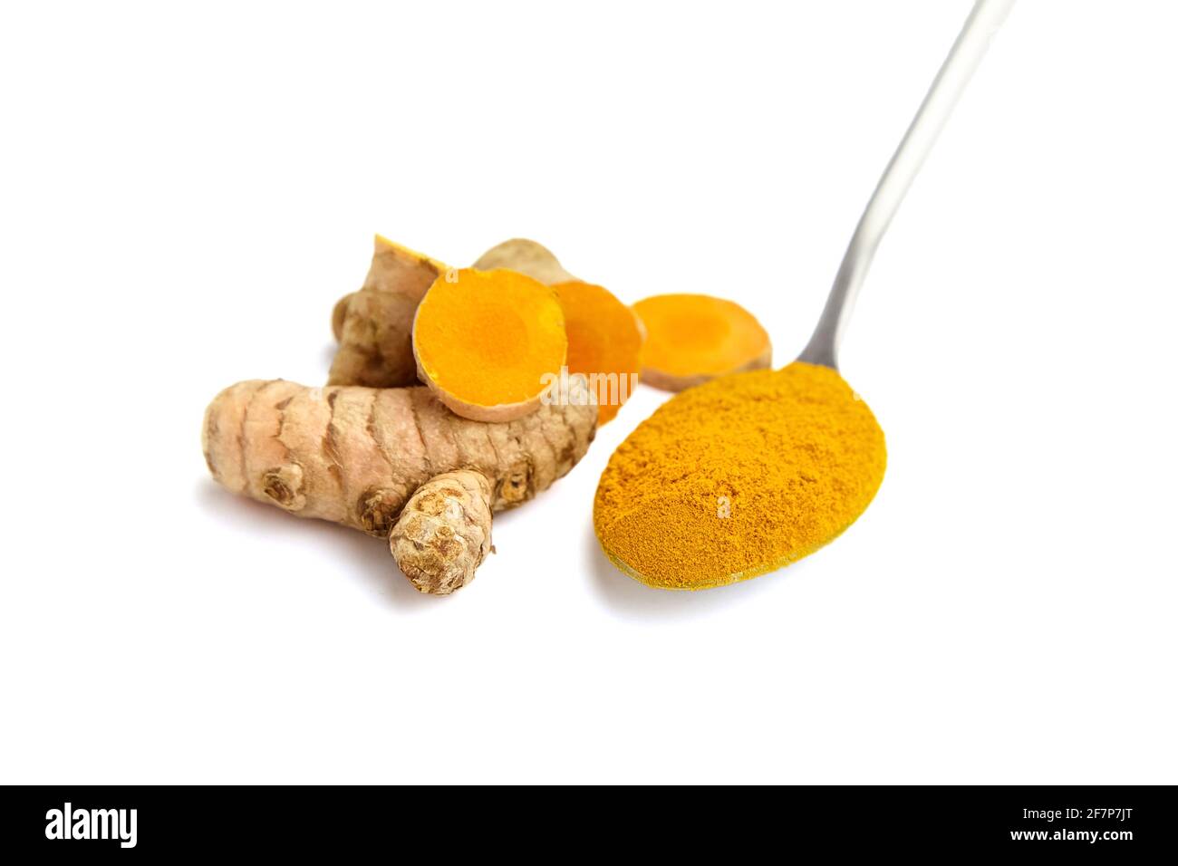 Curcuma roots and powder in spoon isolated on white background. Halved ...