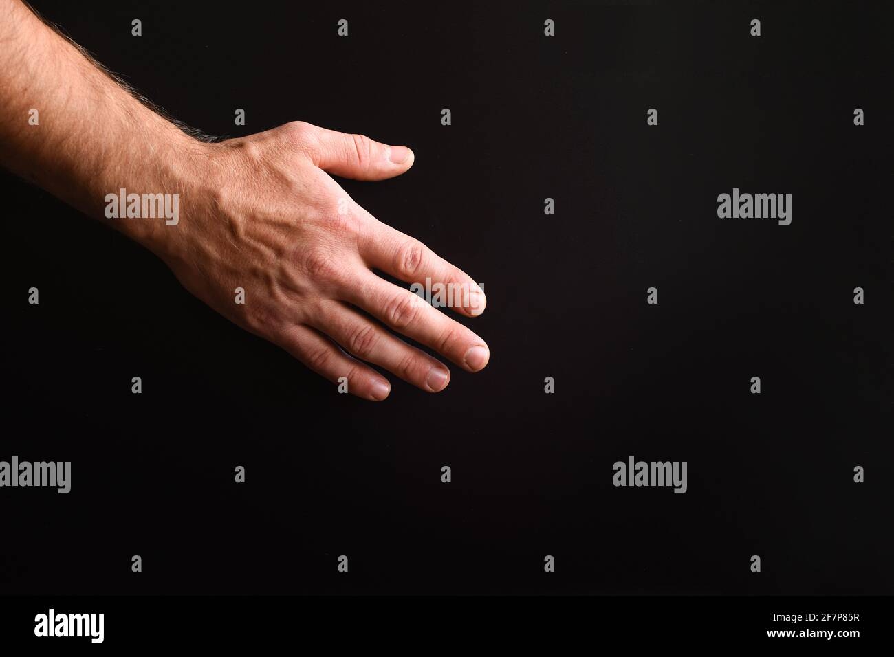 a man's hand on a black background Stock Photo - Alamy