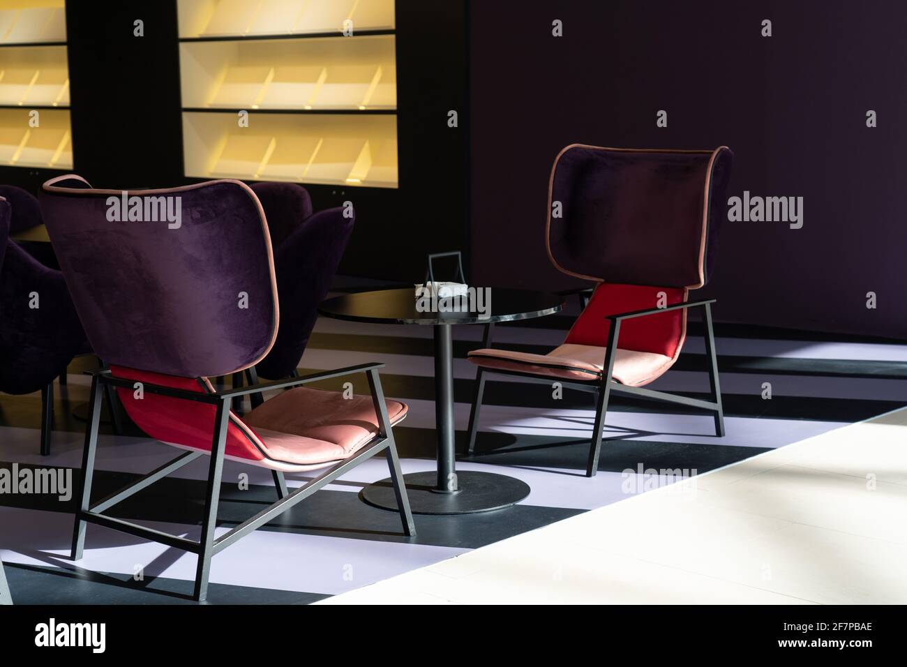A row of tables with soft comfortable violet chairs for visitors to the ...