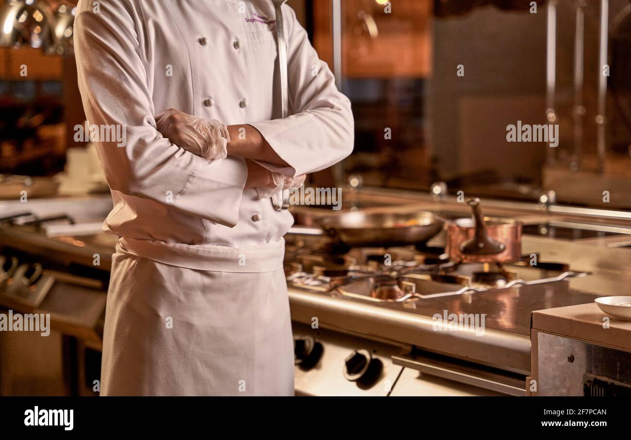 Hands of a chef folded on his stomach Stock Photo - Alamy