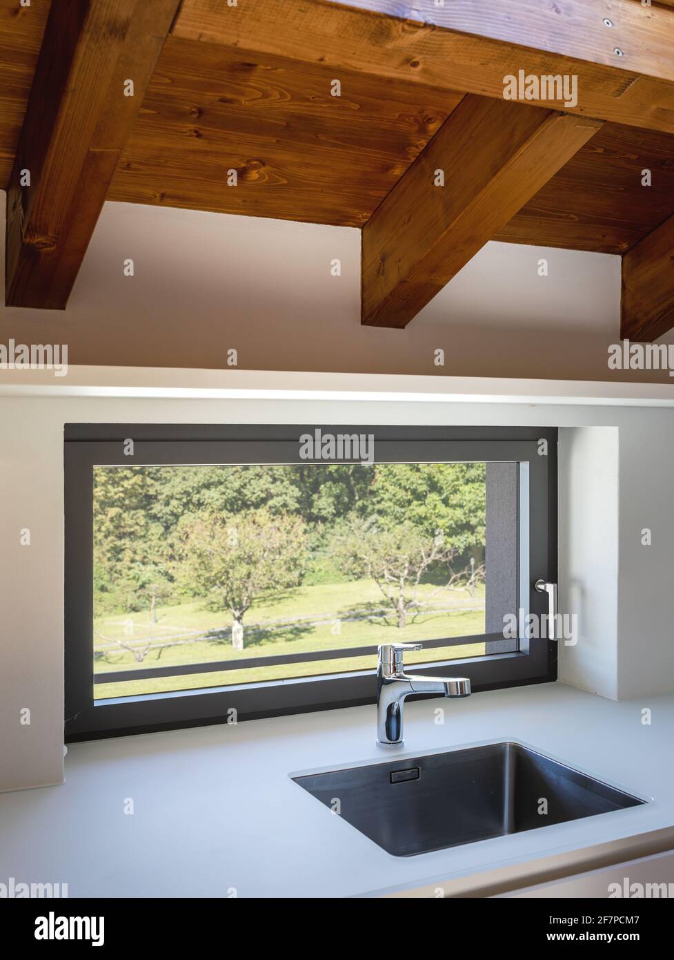 Modern white kitchen detail with steel sink and window overlooking ...