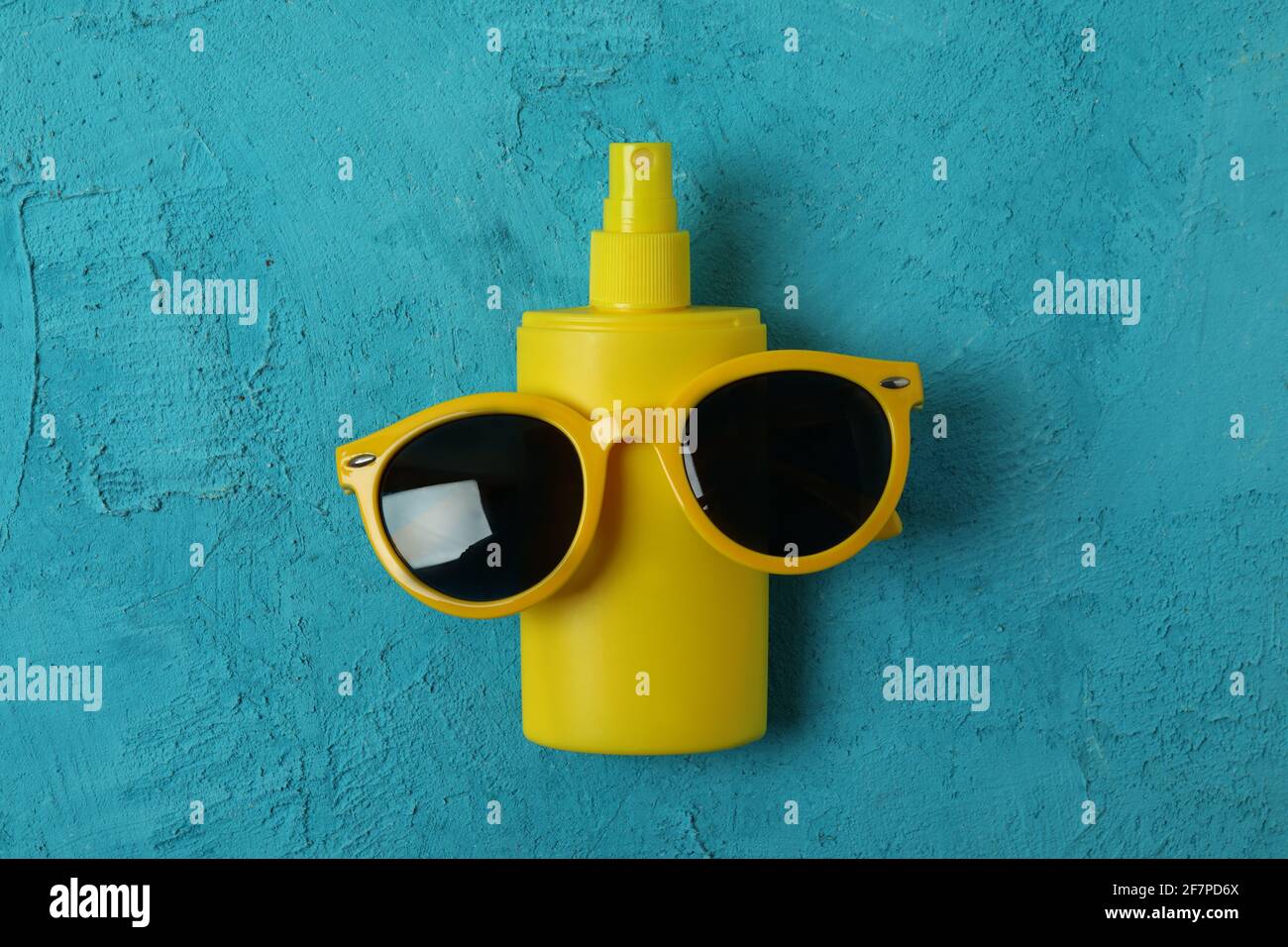 Sunscreen and sunglasses on blue textured background Stock Photo - Alamy