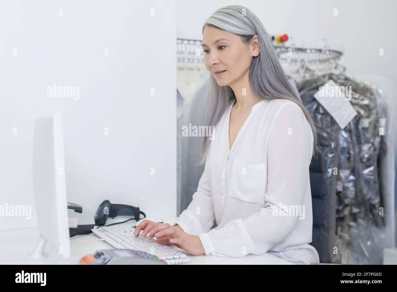 Woman standing behind counter hi-res stock photography and images - Alamy