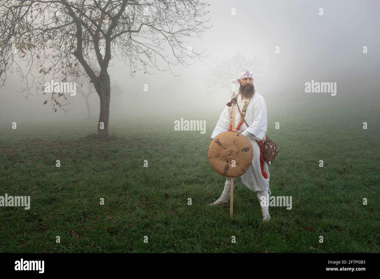 Man is standing in traditional japanese shugendo outfit on green meadow ...
