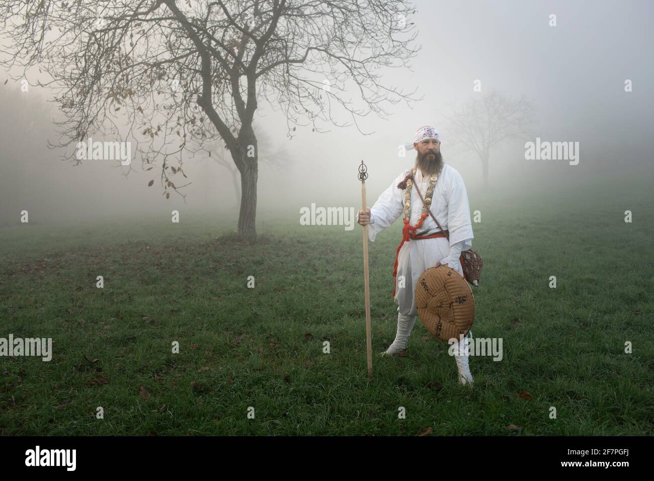 Man is standing in traditional japanese shugendo outfit on green meadow ...