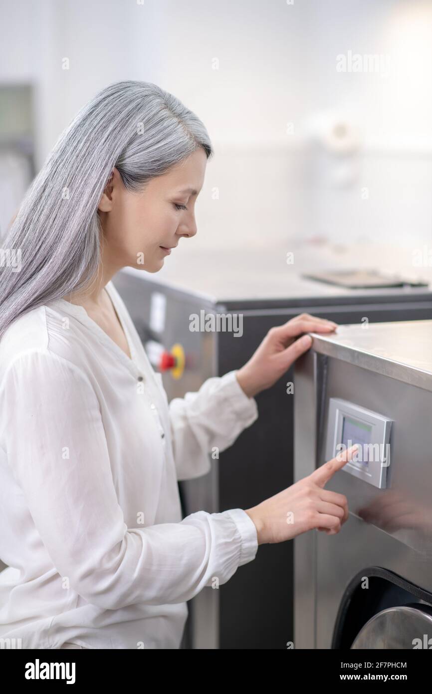 Profile of woman touching finger to control panel Stock Photo - Alamy