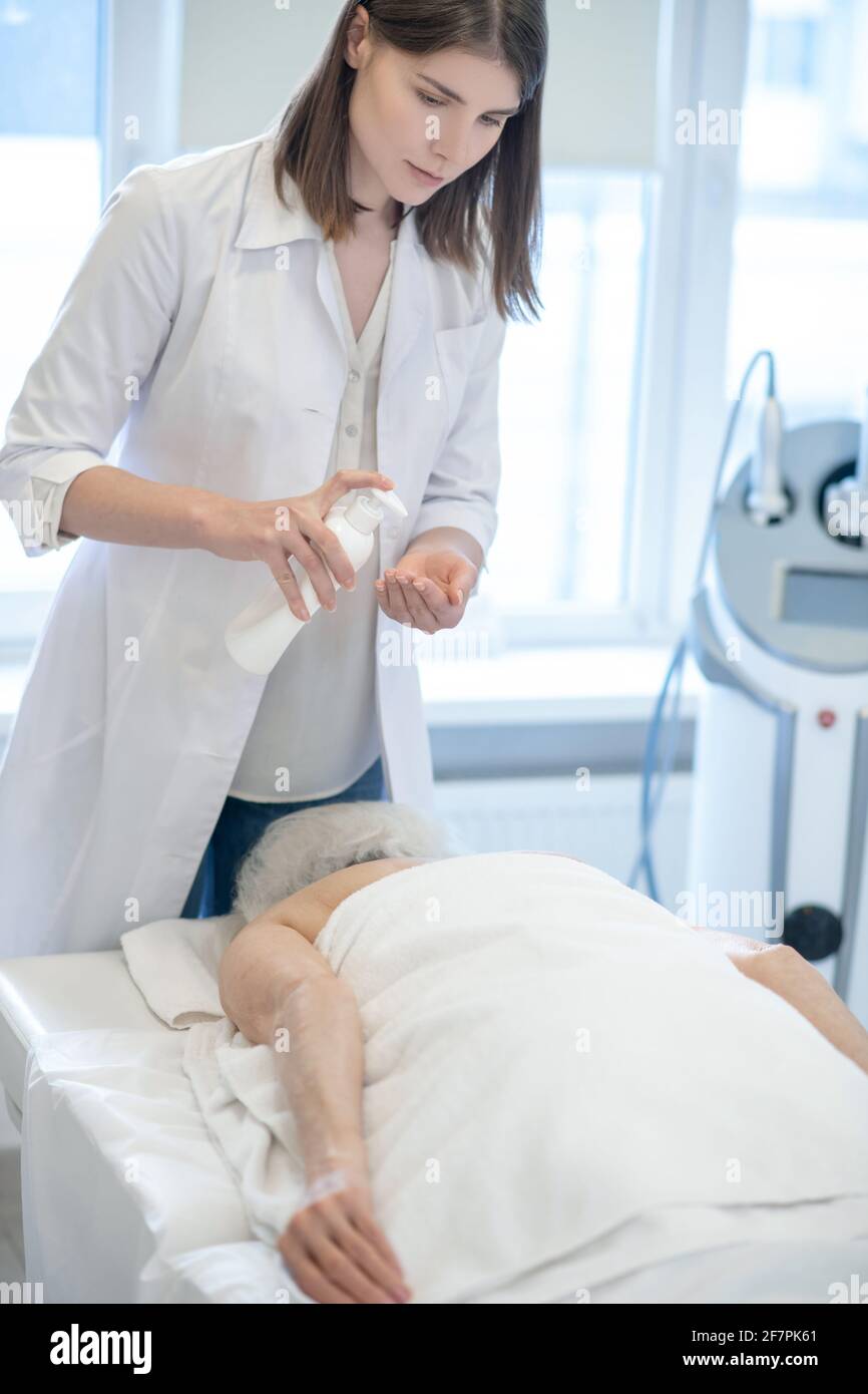 Female massage therapist doing back massage procedures to a woman Stock ...