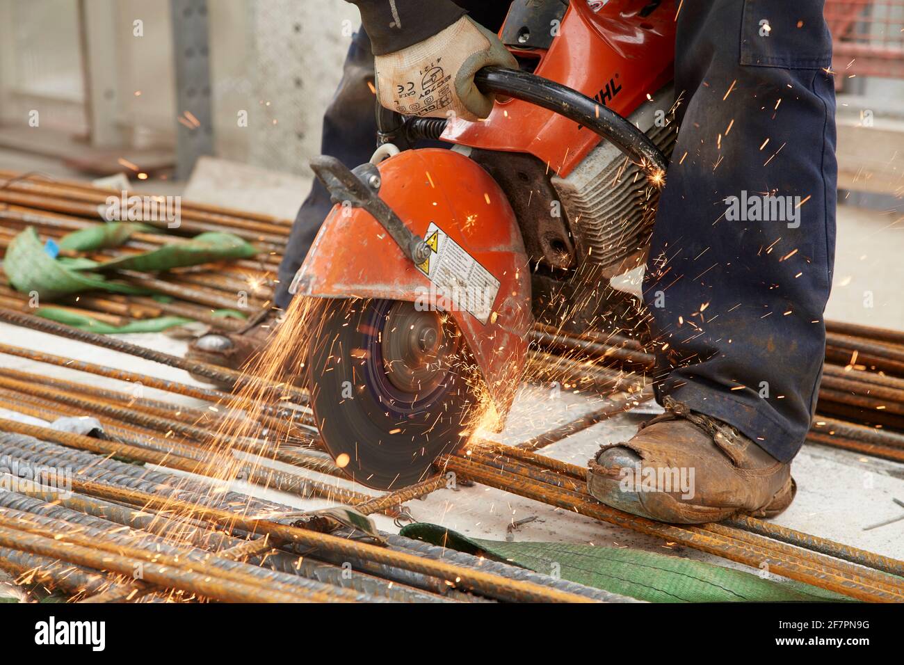 Construction worker using angle grinder during concrete pour for tower ...