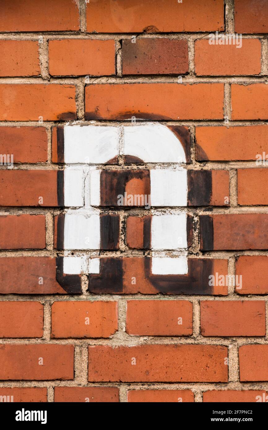 A white letter n painted on a red brick wall Stock Photo - Alamy