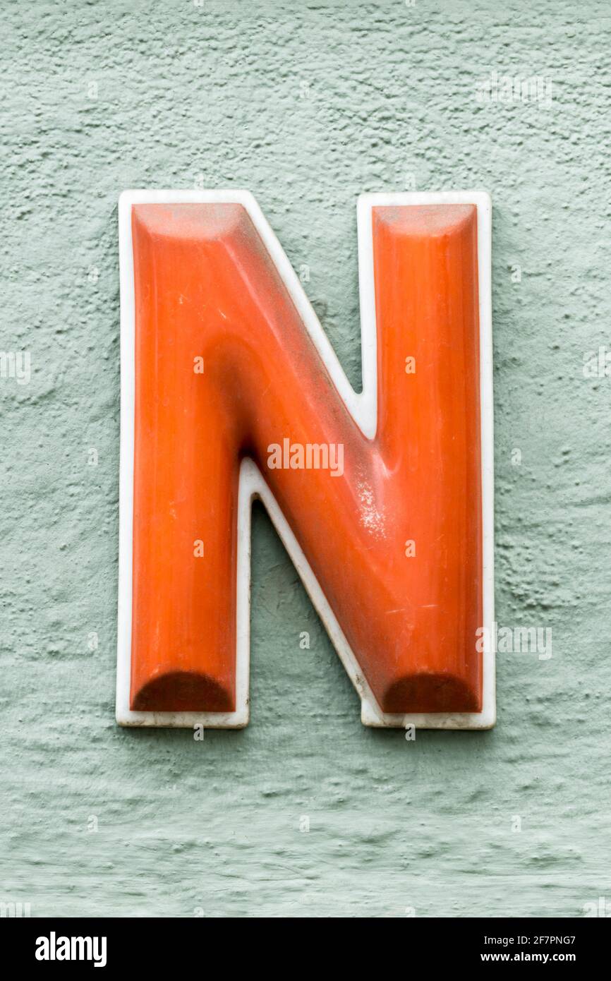 Orange letter N with white outline against light green background Stock ...