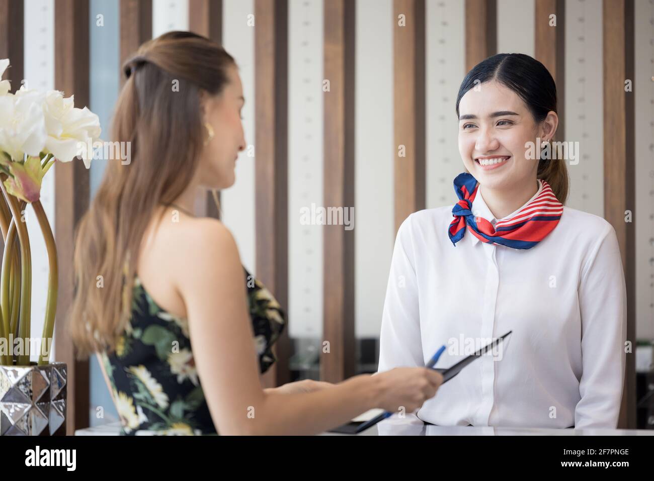 tourist woman going to fill and sign hotel check in registration form ...