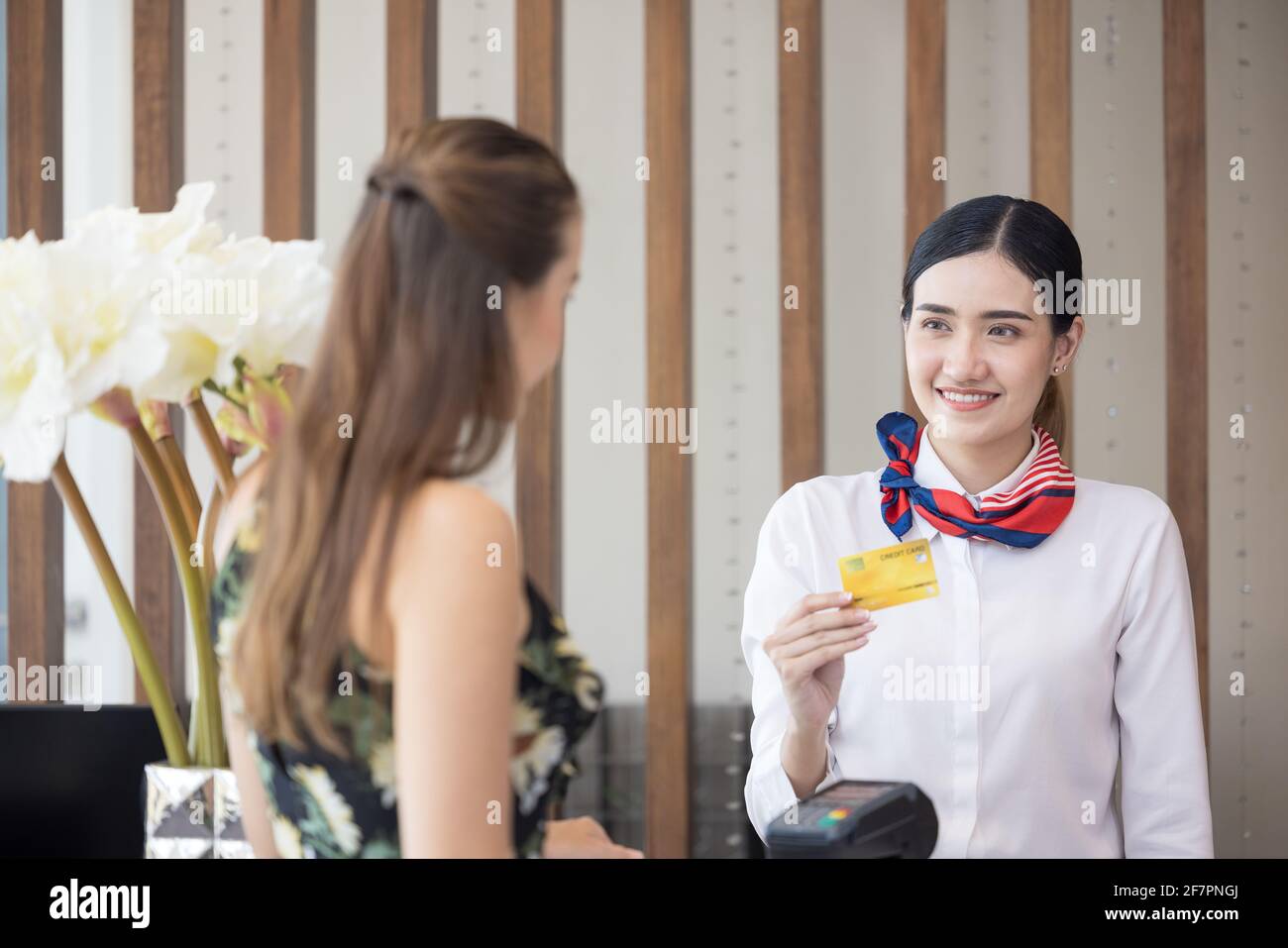 Guest makes card payment for services at check-in desk of hotel ...