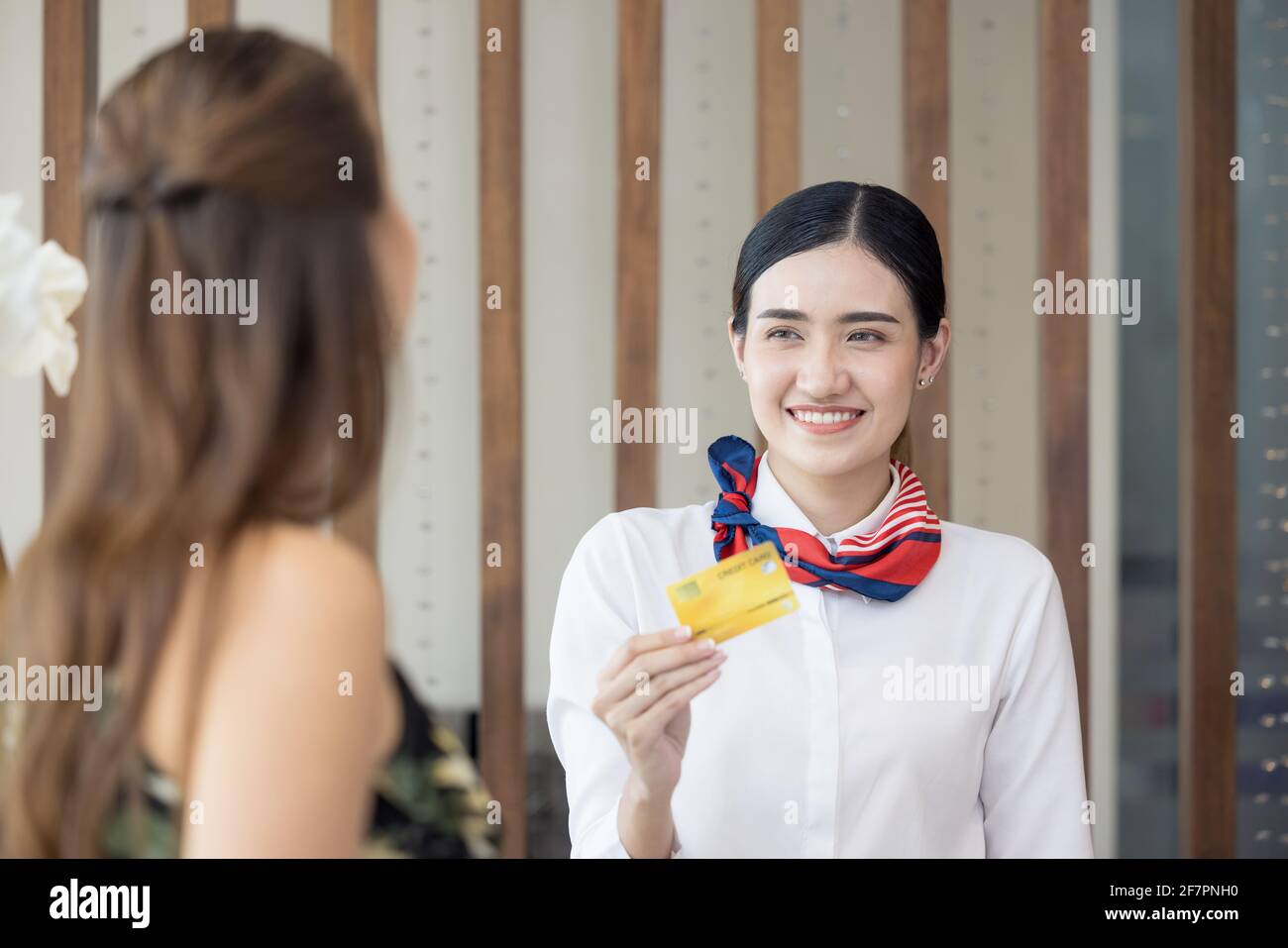 Guest makes card payment for services at check-in desk of hotel ...