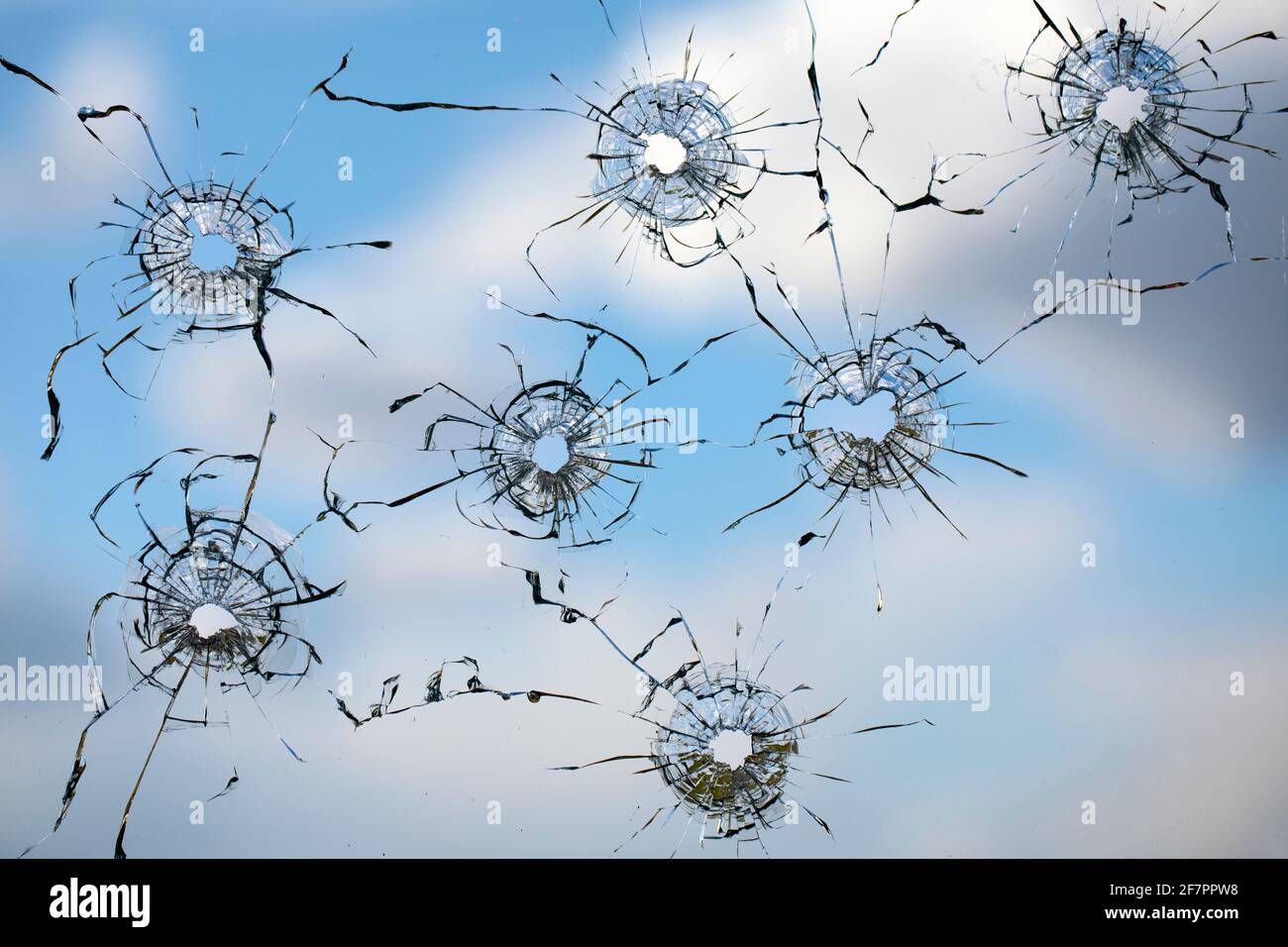 holes and cracks from bullets in glass, on sky background Stock Photo ...
