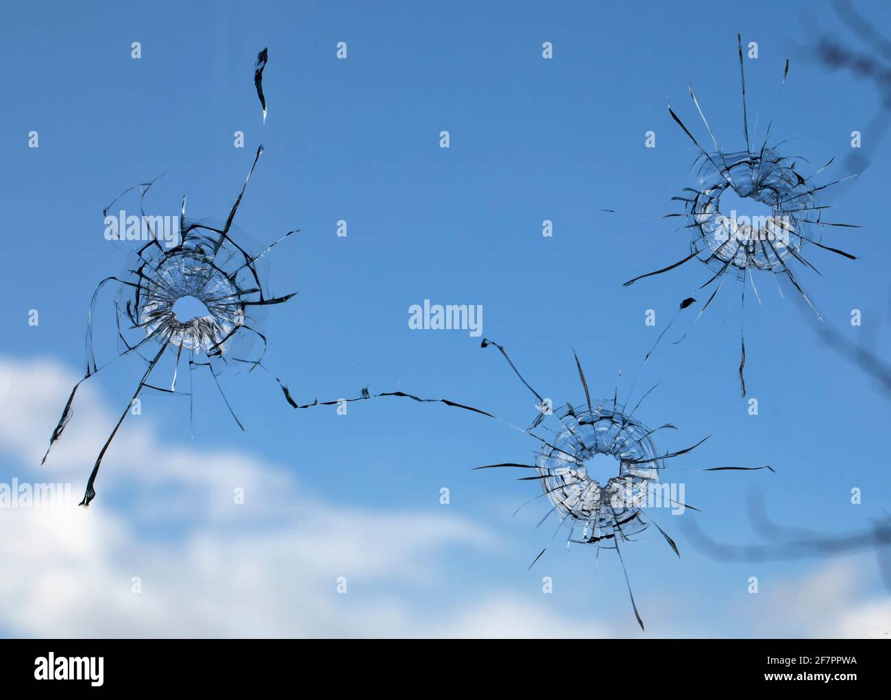 holes and cracks from bullets in glass, on sky background Stock Photo ...