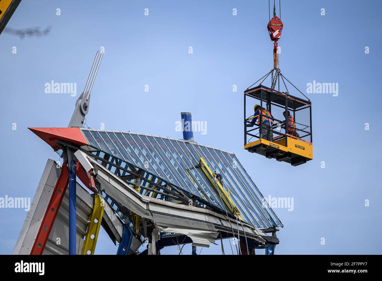 Two construction workers are working in a construction cage at a dizzy ...