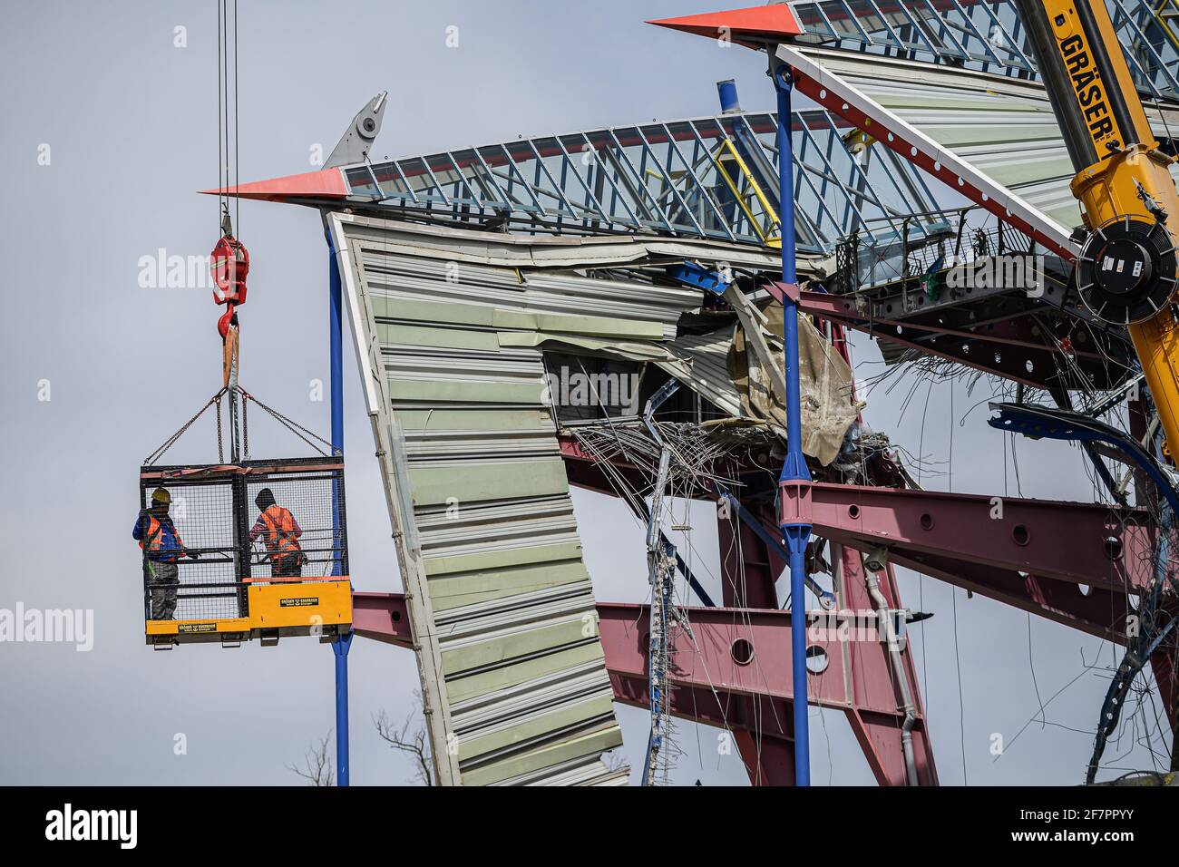 Two construction workers are working in a crane cage at a dizzy height ...