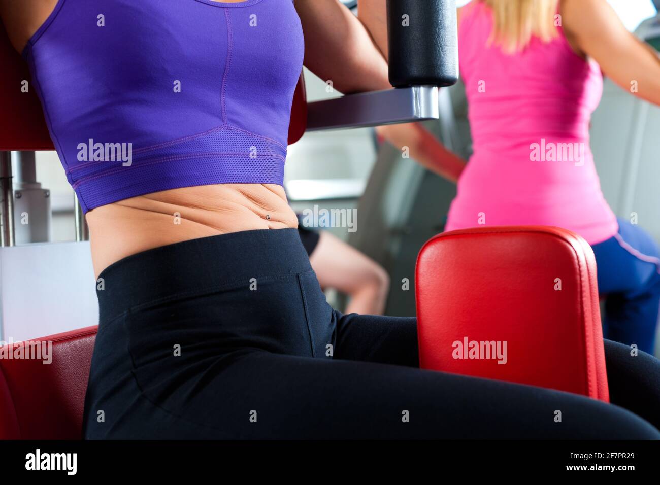 Three young women doing strength or sports training in gym for a better ...