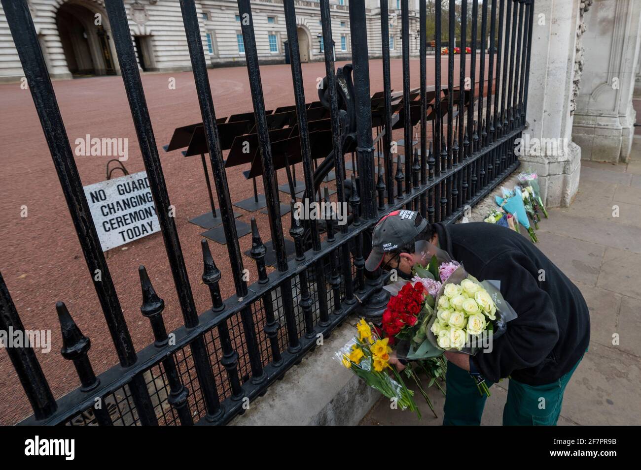 London, UK. 9th Apr, 2021. A man lays flowers outside Buckingham Palace ...